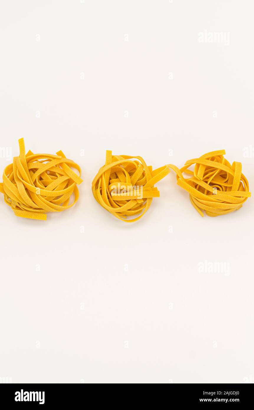italian tagliatelle pasta nests on a white background - natural food ...