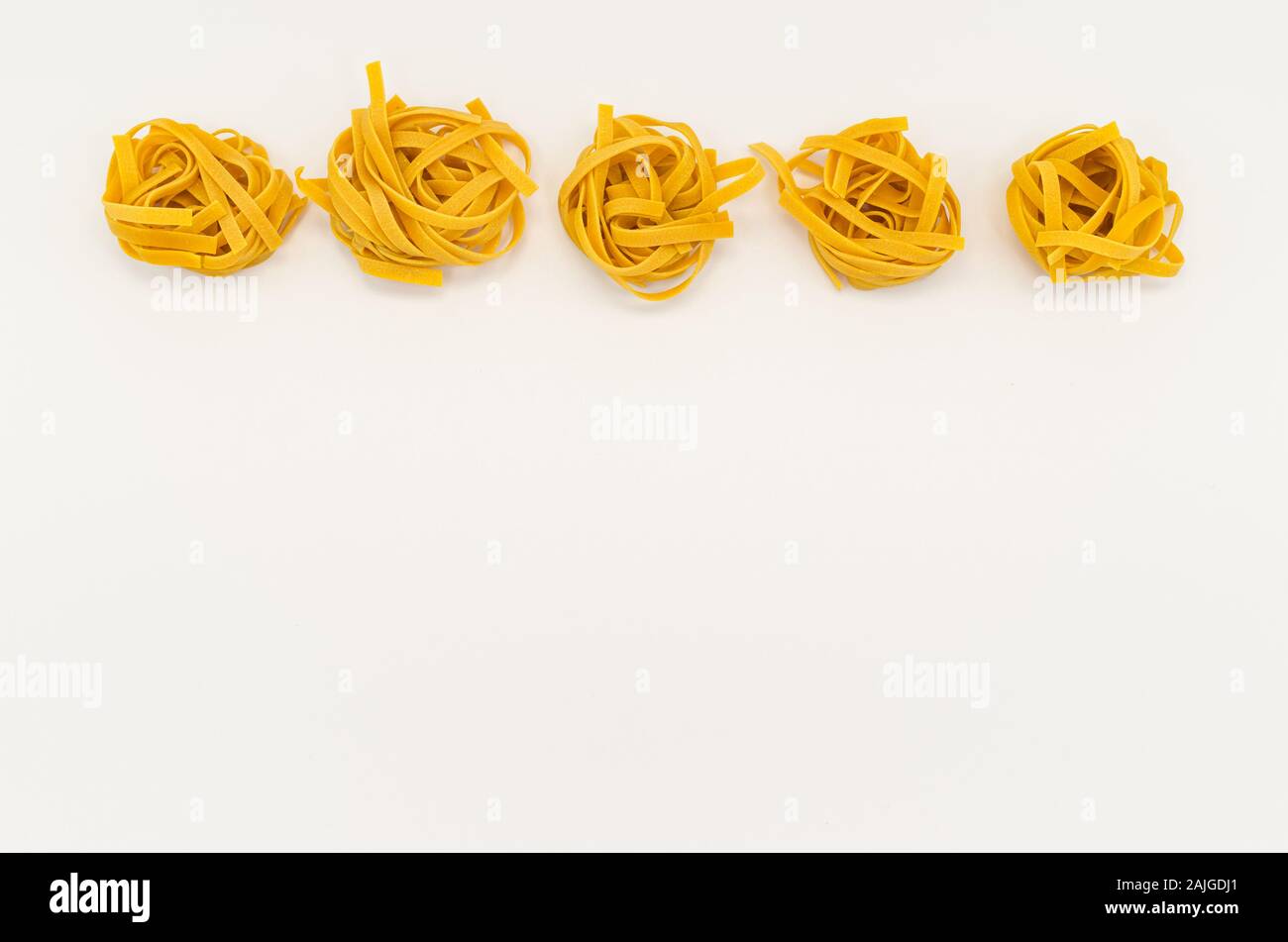 italian tagliatelle pasta nests on a white background - natural food ...