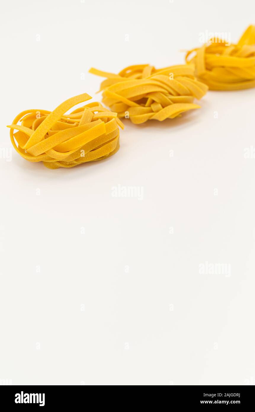 italian tagliatelle pasta nests on a white background - natural food ...