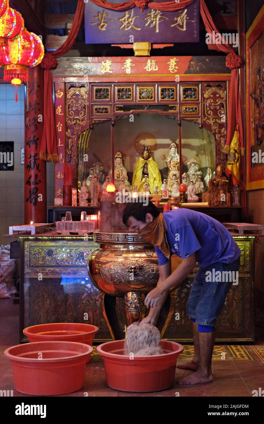 A man cleans the incense ashes in a Buddhist Temple. This yearly ritual ...