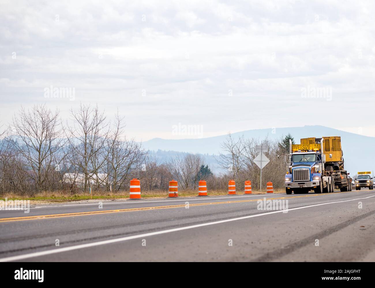 Blue big rig heavy duty classic bonnet semi truck with oversize load ...