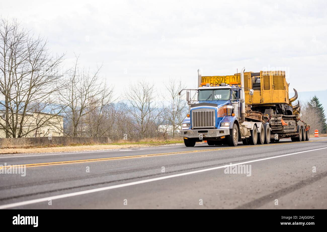 Blue big rig heavy duty classic bonnet semi truck with oversize load ...