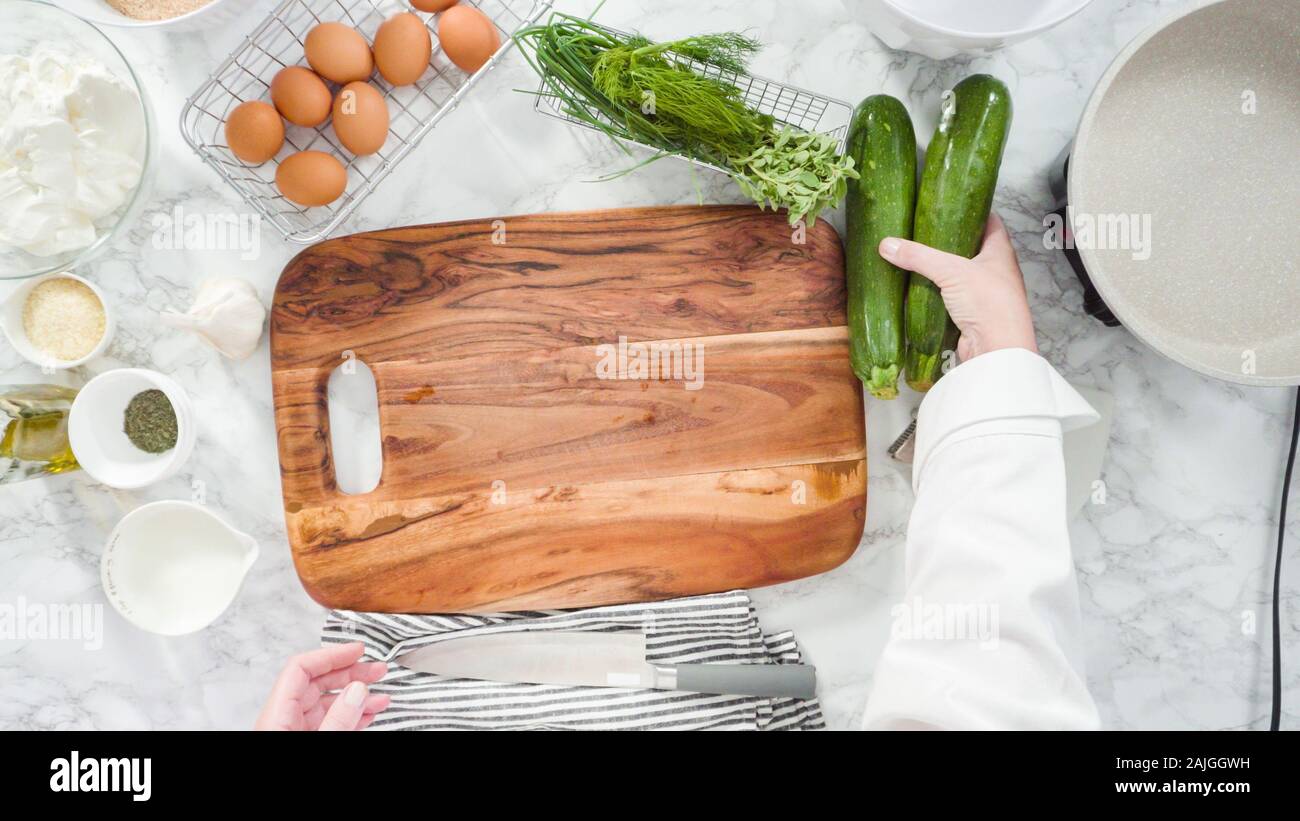 Flat lay. Step by step. Cutting ingredients to make zucchini cakes with ...