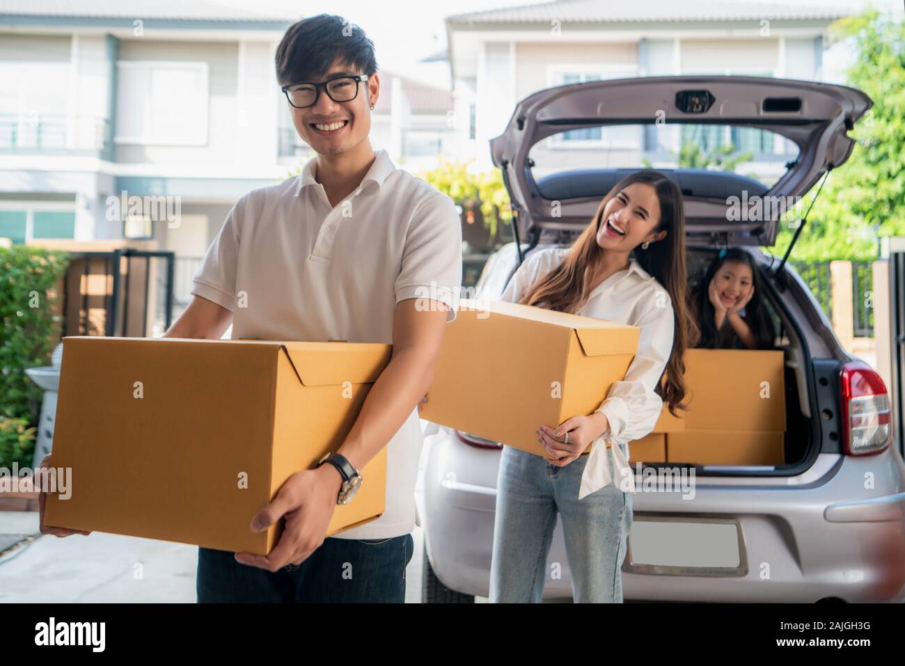 Happy Asian family with father and mother is standing near car with ...