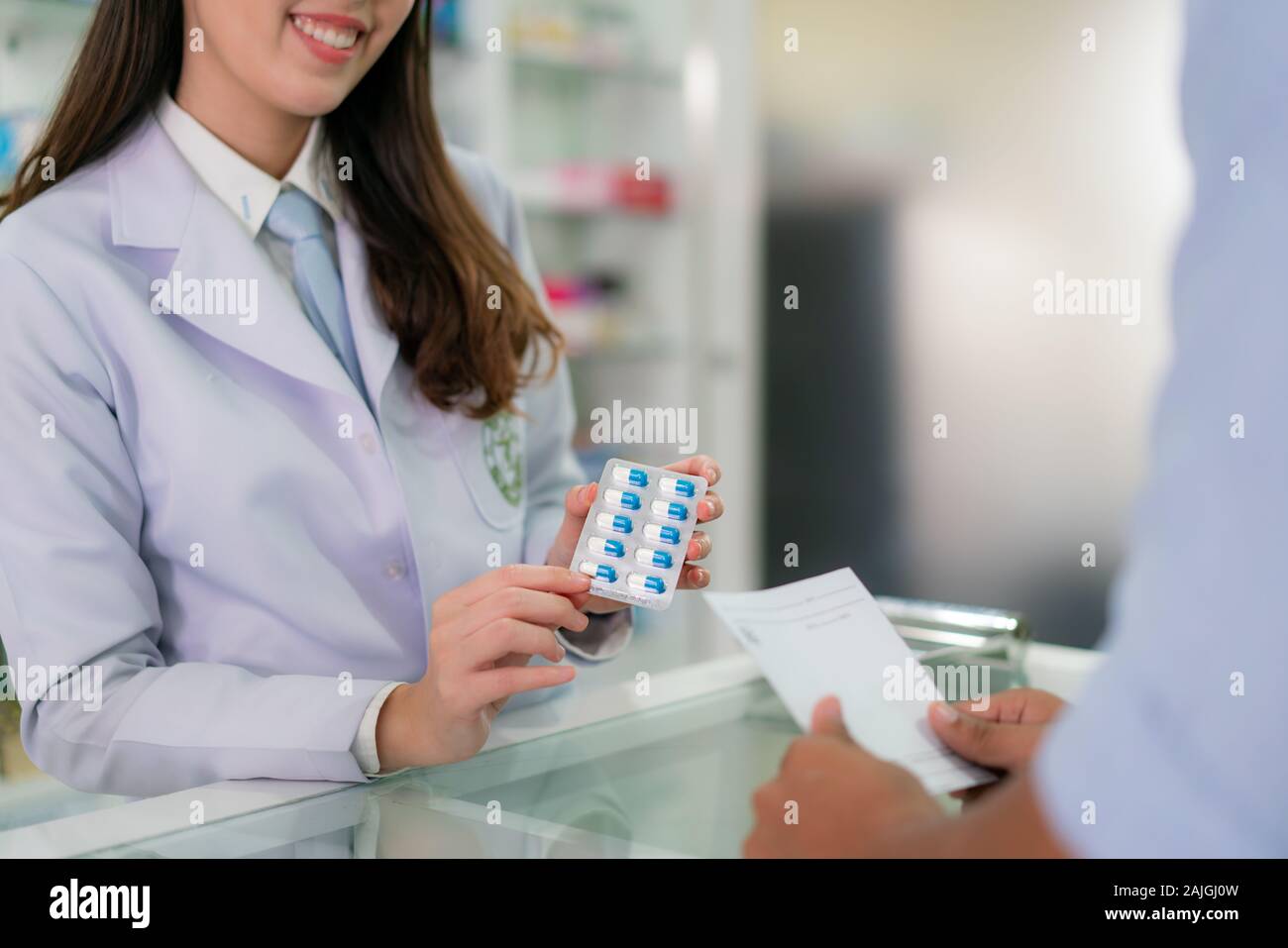 Confident Asian young female pharmacist with a lovely friendly smile ...