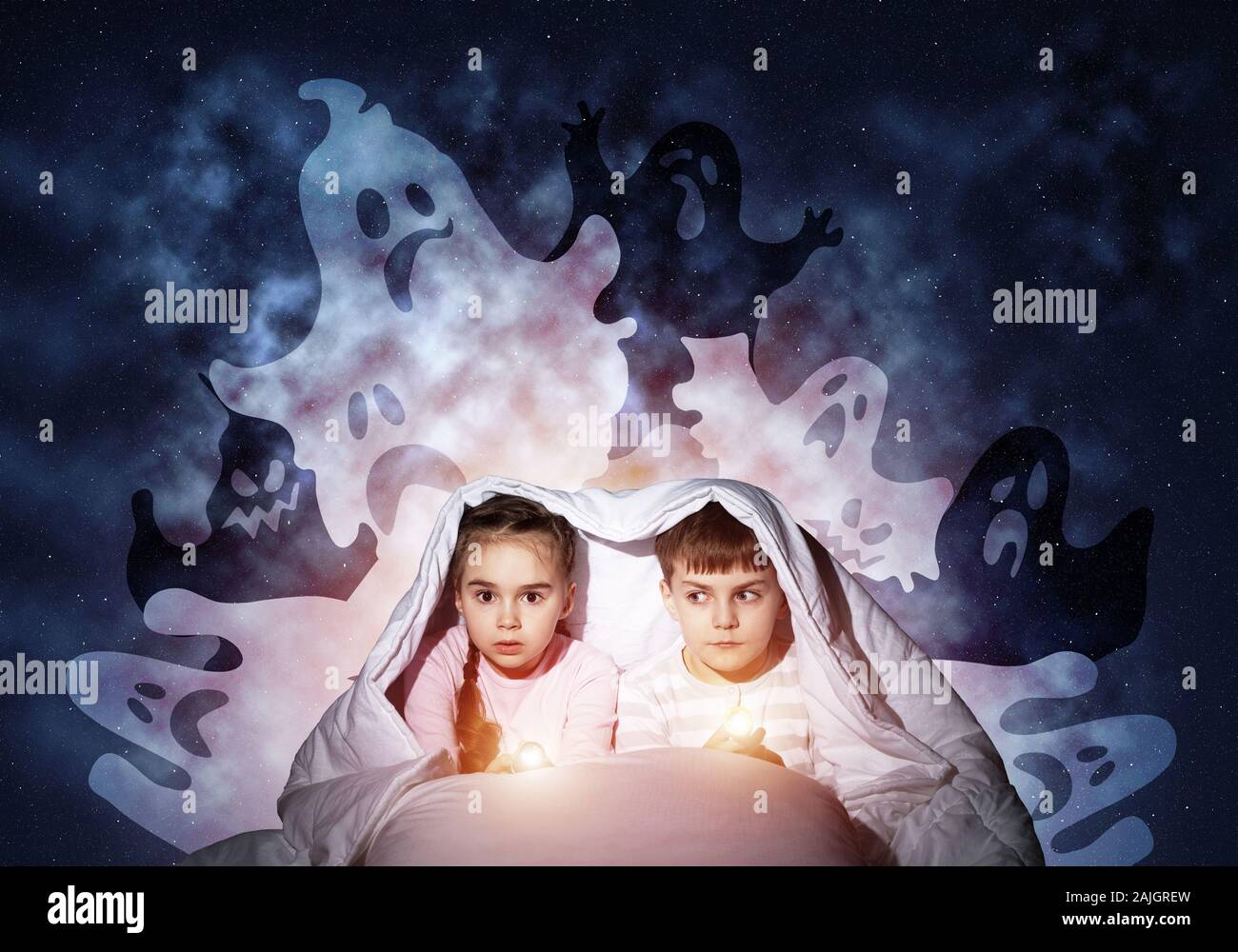 Scared girl and boy with flashlights hiding under blanket from ...