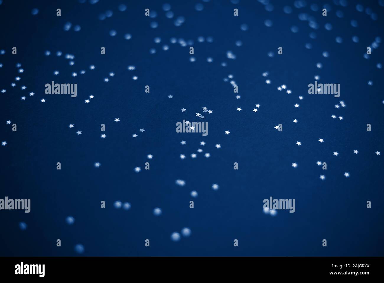Glowing Mica Silver Stars Confetti On Blue Color Trendy Background