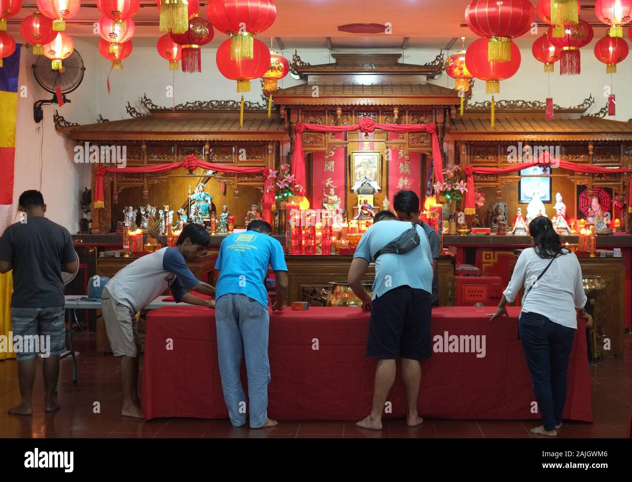 A group of people prepare an altar in a Buddhist Temple before Chinese ...