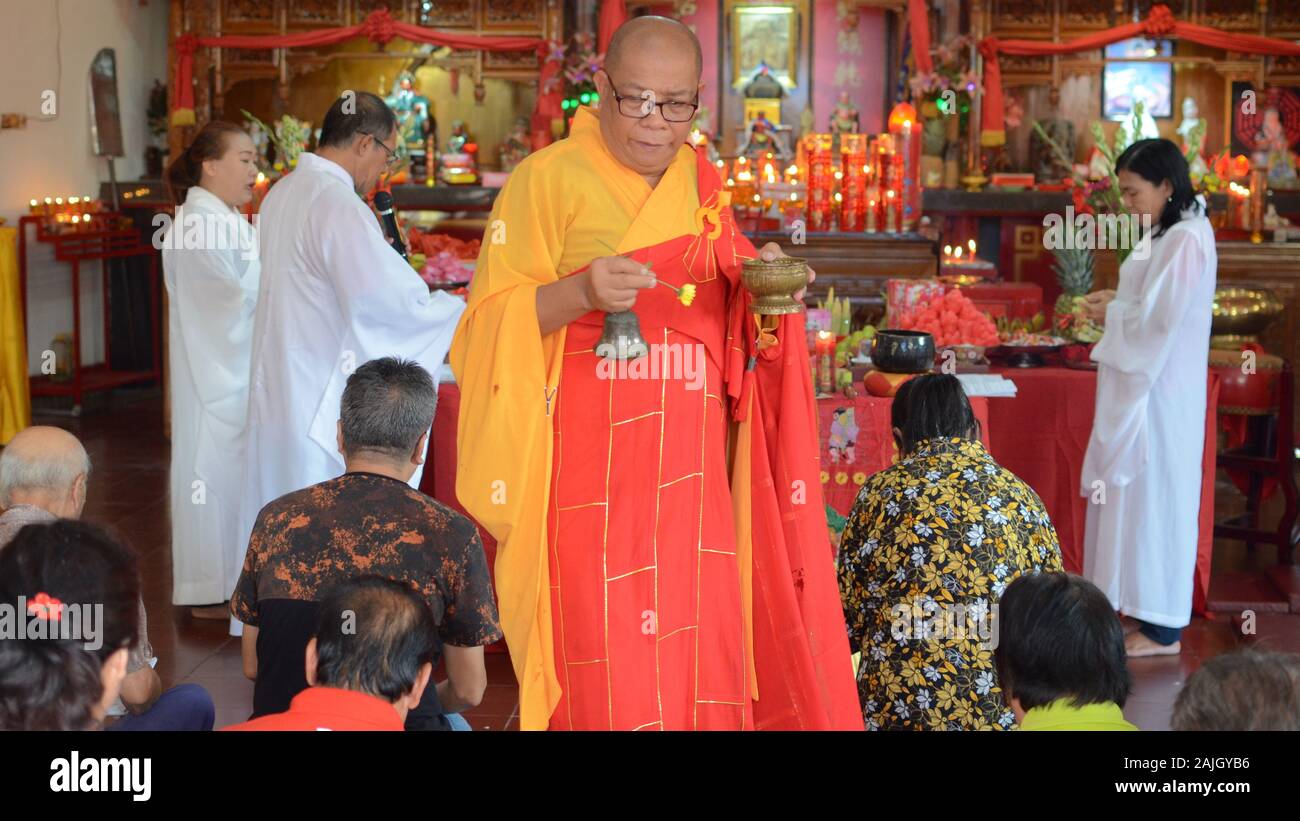 A Buddhist priest is blessing some people in a temple before The ...
