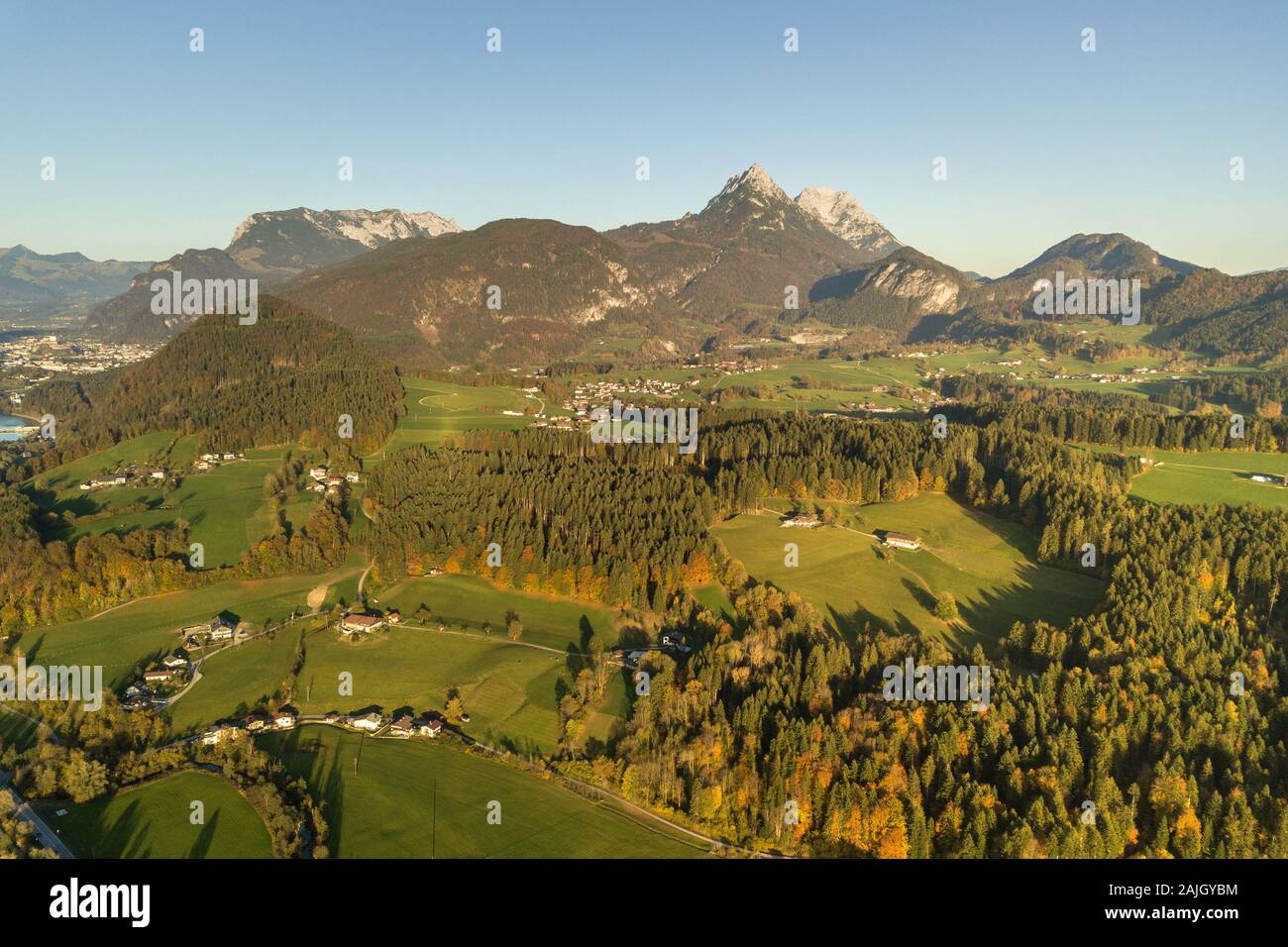 Aerial view of green meadows with villages and forest in austrian Alps ...