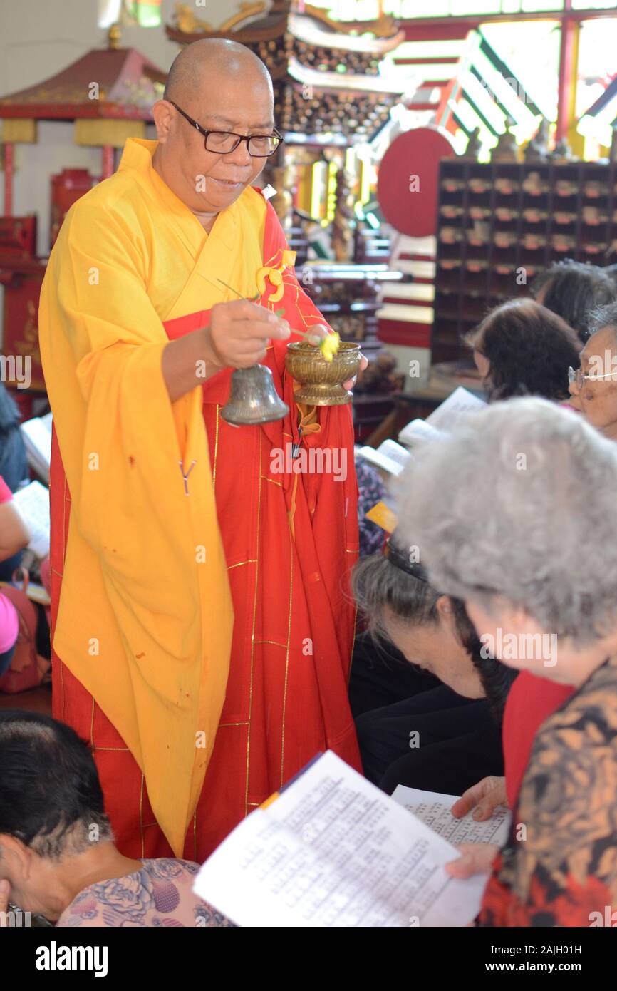 A Buddhist priest is blessing some people in a temple before The ...