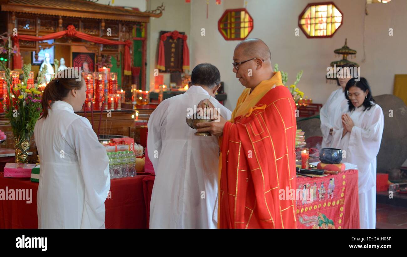 A Buddhist priest is blessing some people in a temple before The ...