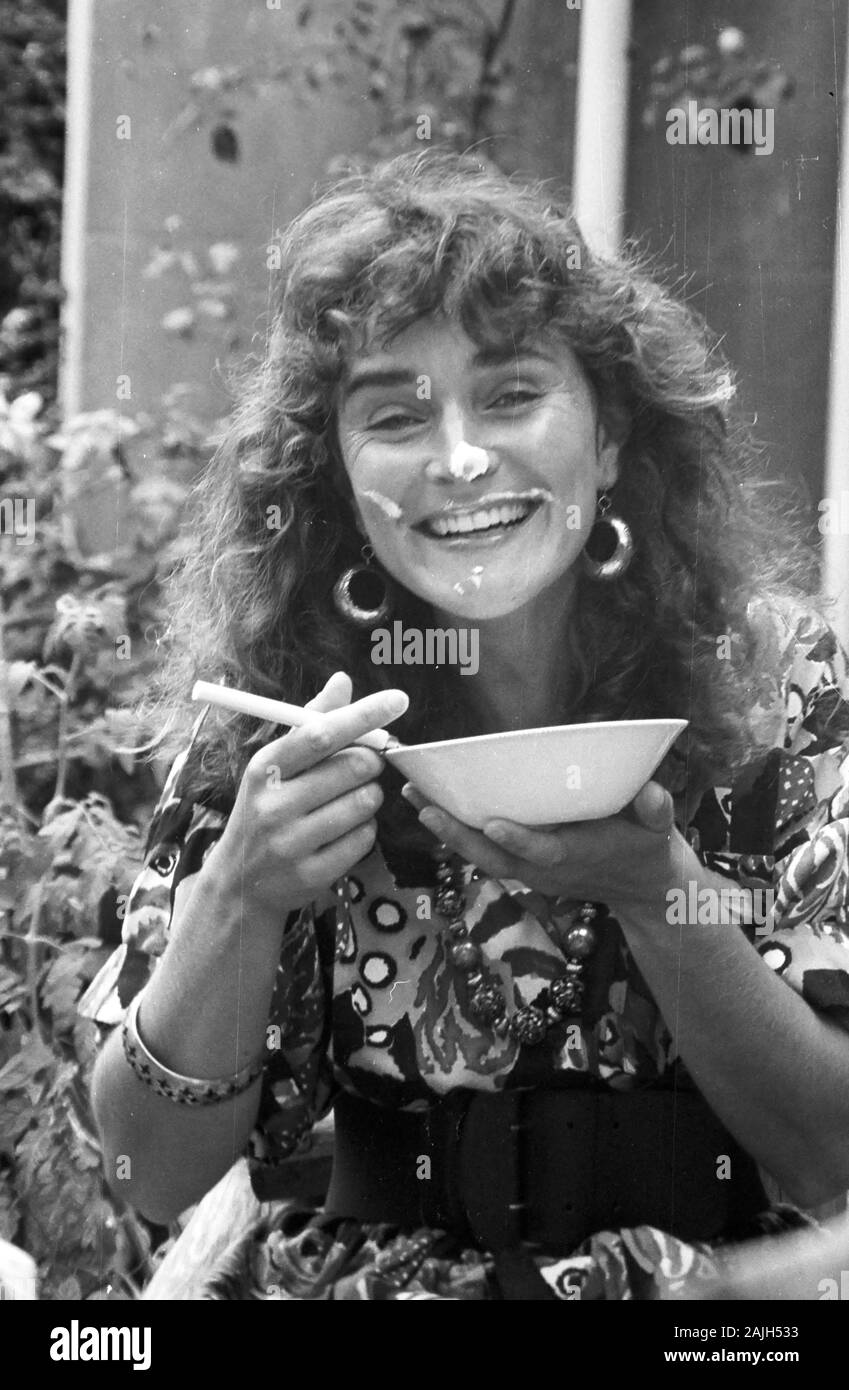 Pretty 20-something girl laughing with cream plastered over her face ...