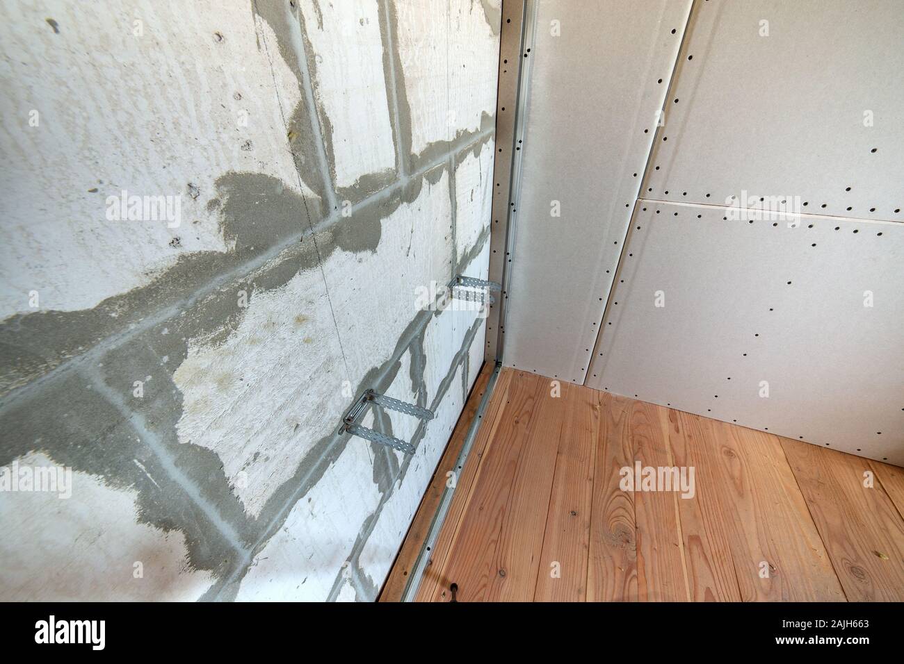 Unfinished brick wall in a room under construction prepared for drywall ...