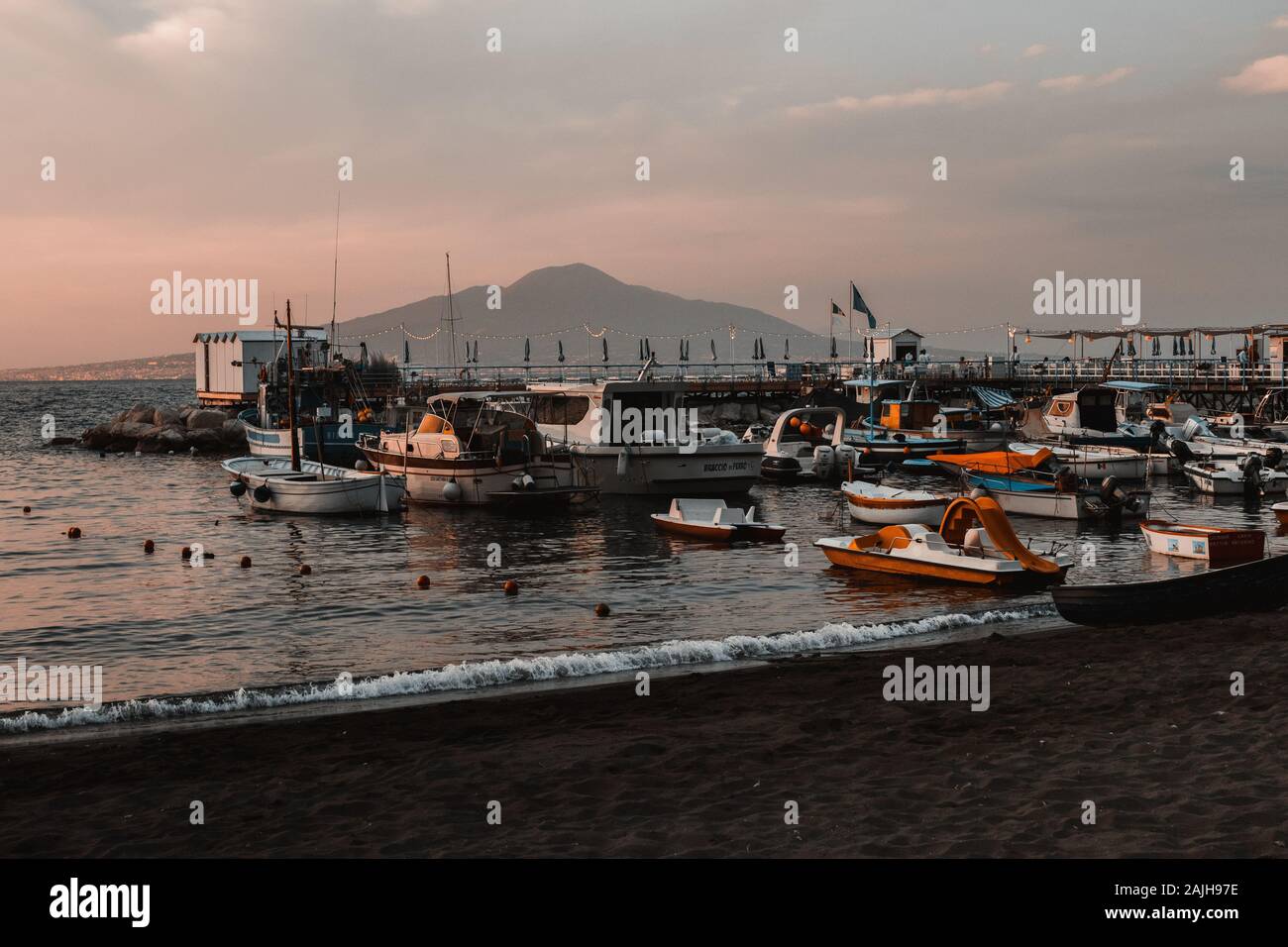 A group of boats at sunset overlooked by Vesuvio Stock Photo - Alamy