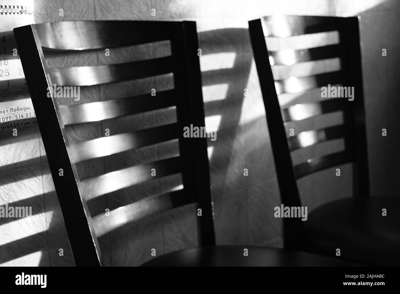 Old wooden chairs, side view in sunny room, bw photo Stock Photo - Alamy