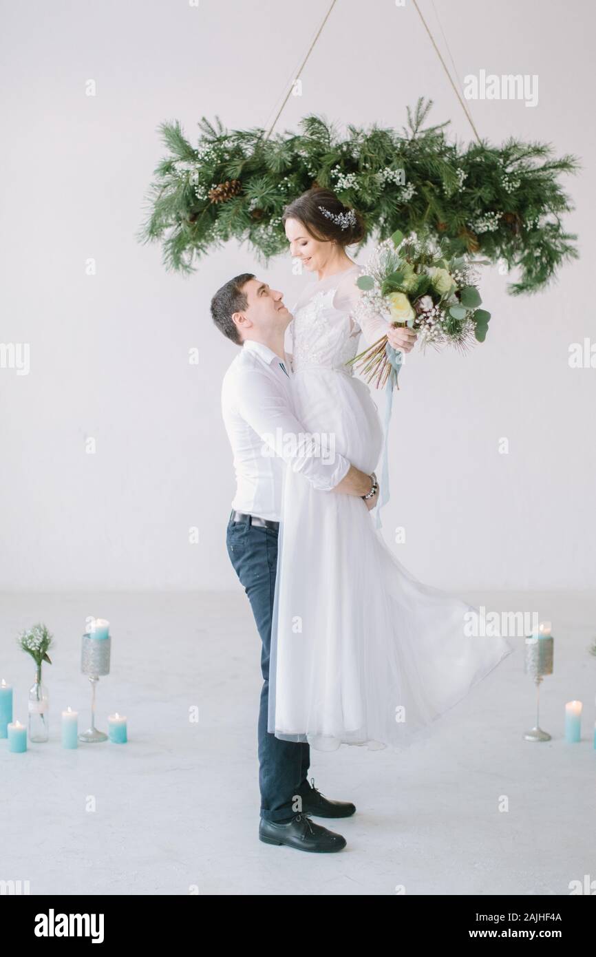 The groom lifted the bride up in his arms. The bride in luxury white ...