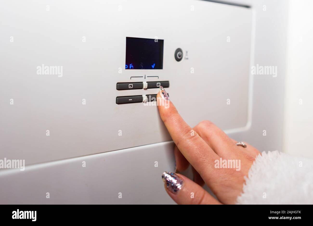Control panel of central heating. Hand adjusting the room temperature ...
