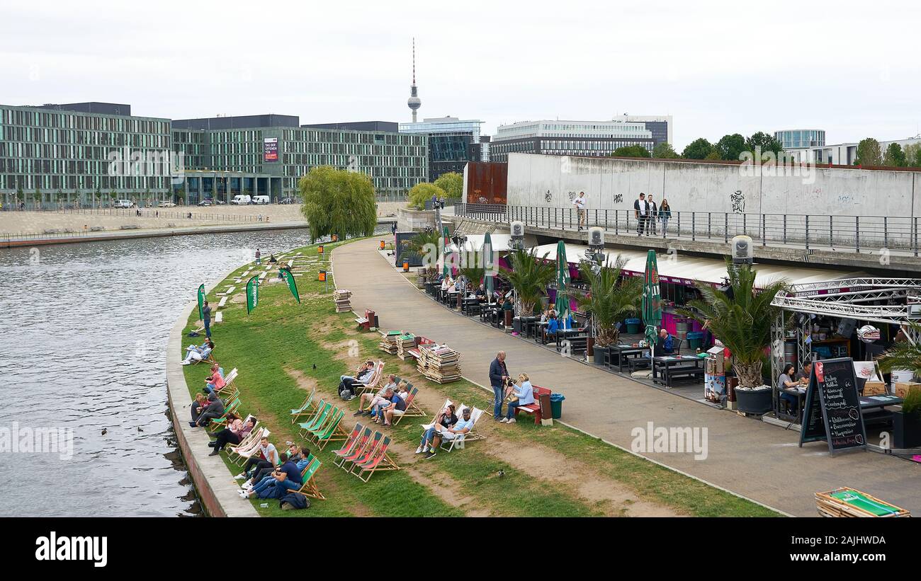 Crowd in lounge chairs soak up some fresh air on the banks of the River ...
