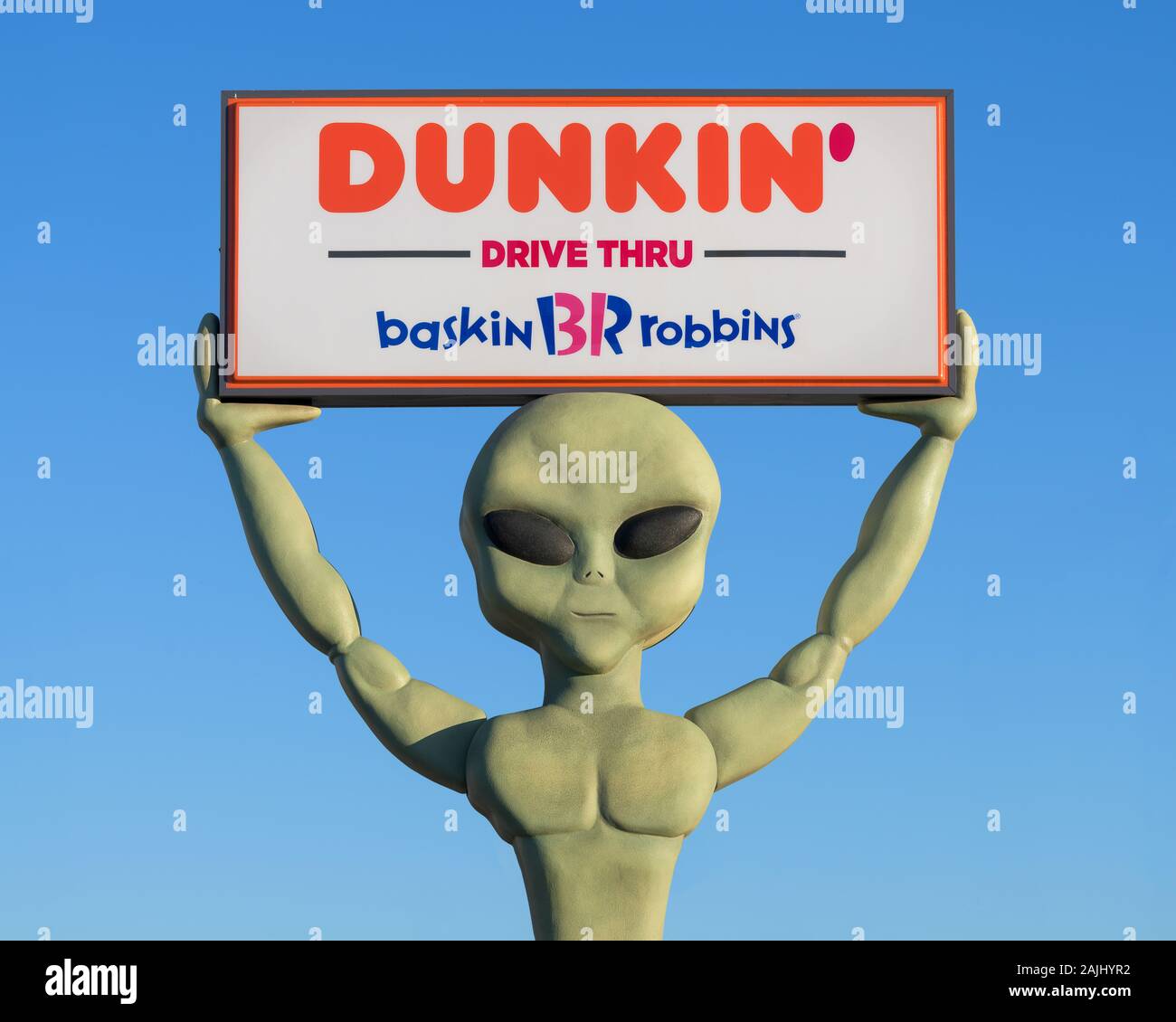 Alien holding up sign at Dunkin Donuts on Main Street in downtown ...