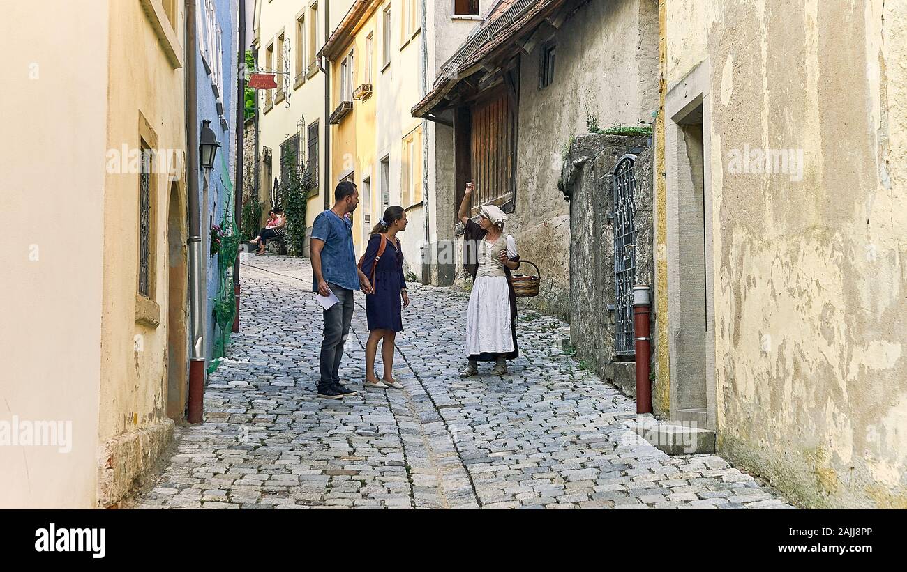Female private tour guide dressed in medieval costume takes a couple on ...