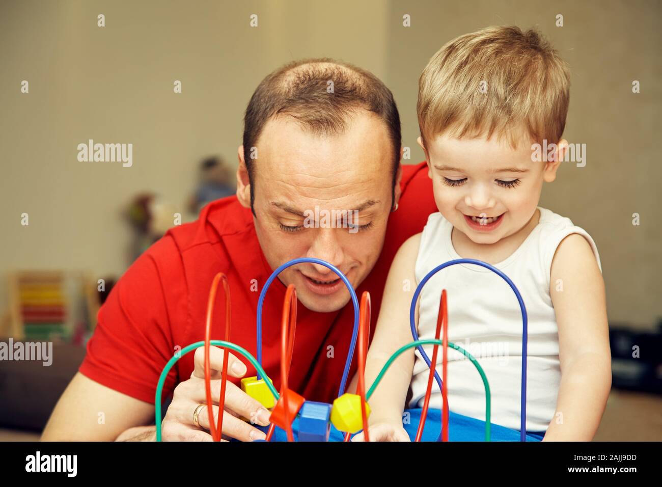 father playing with his child in developing game at home. Dad and son ...