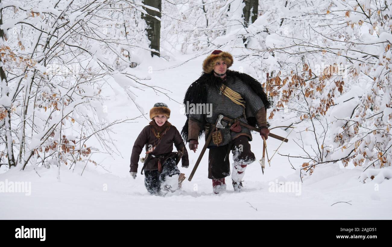Father viking with his son going in the winter forest Stock Photo - Alamy