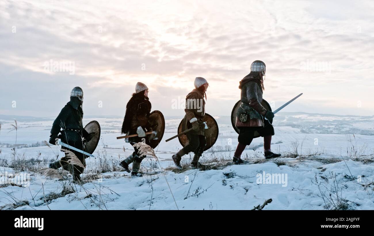 Group of Vikings with shields and swords going forward on the winter ...