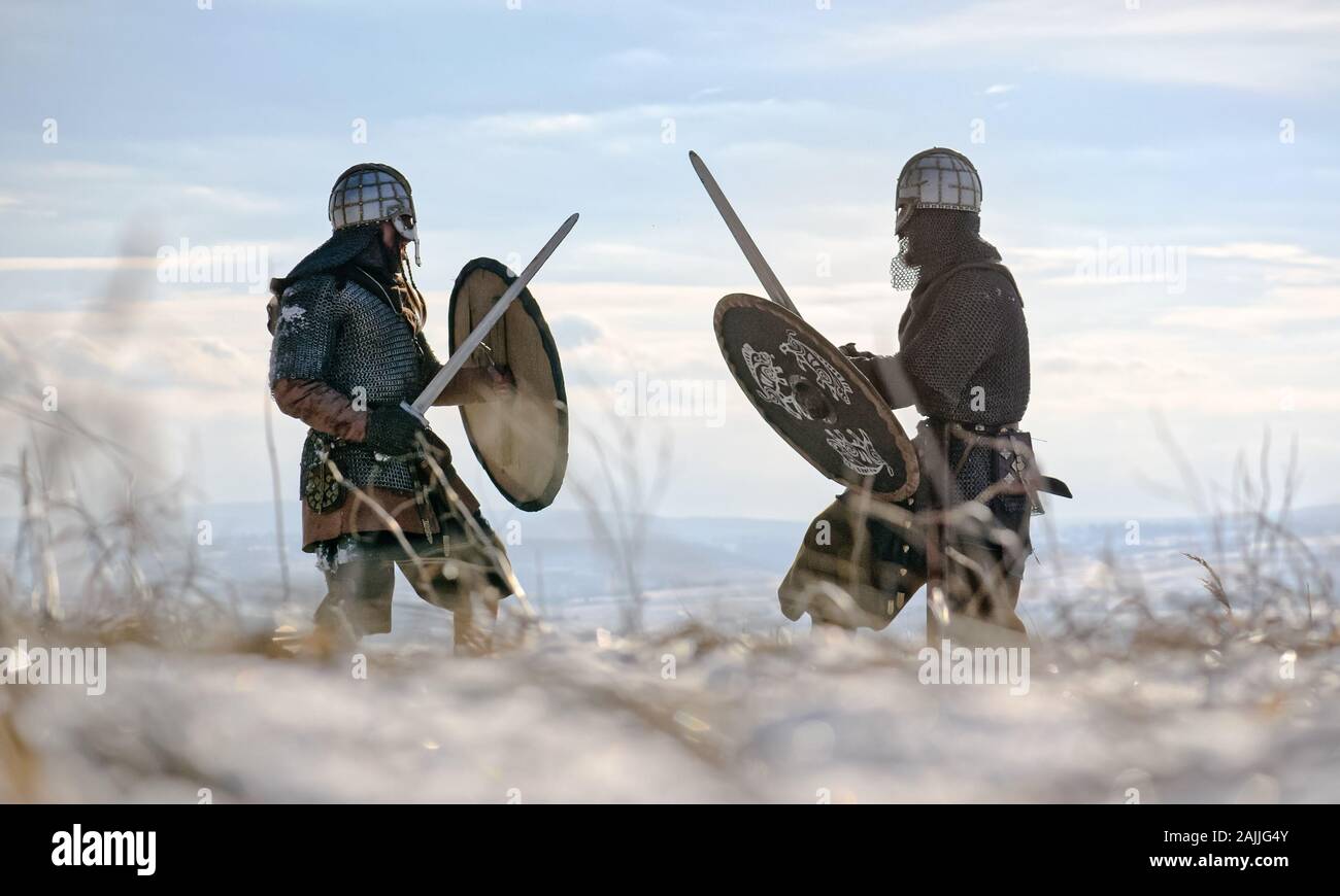 Two warriors viking are fighting with axes and shields on the winter ...