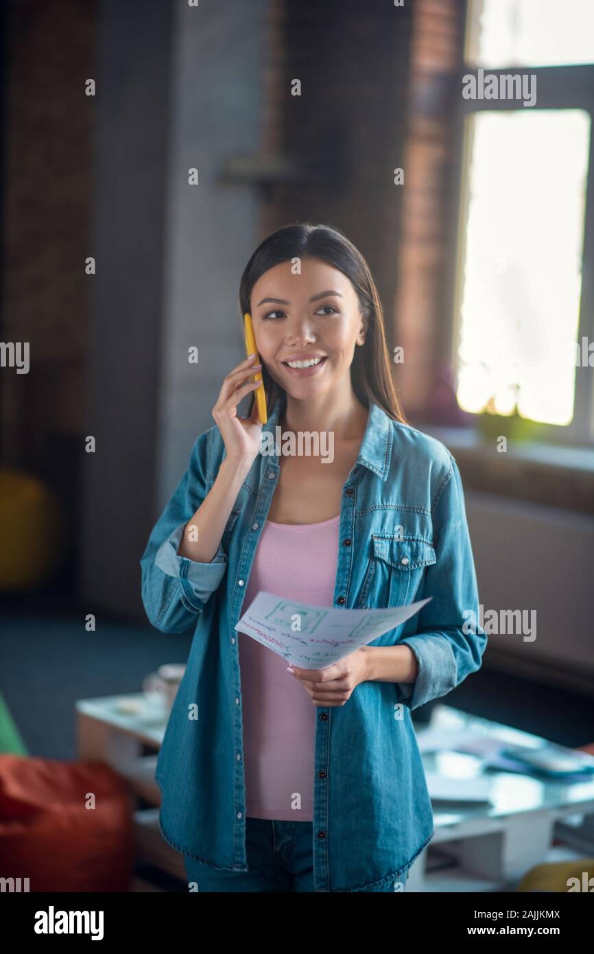 Happy young woman answering smartphone hi-res stock photography and ...