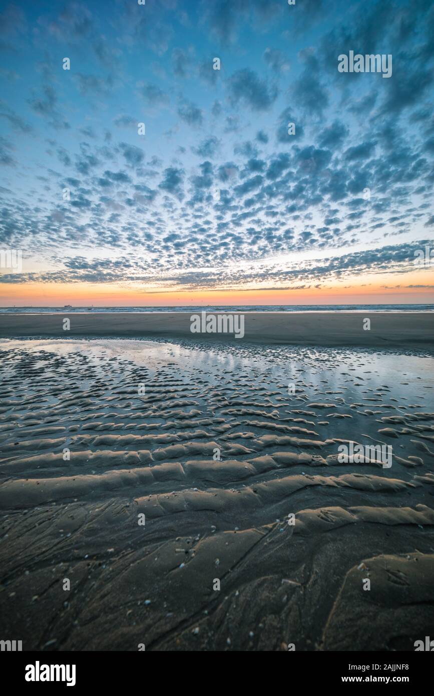 Ripples in the sand of the beach during a colorul sunset at the dutch ...