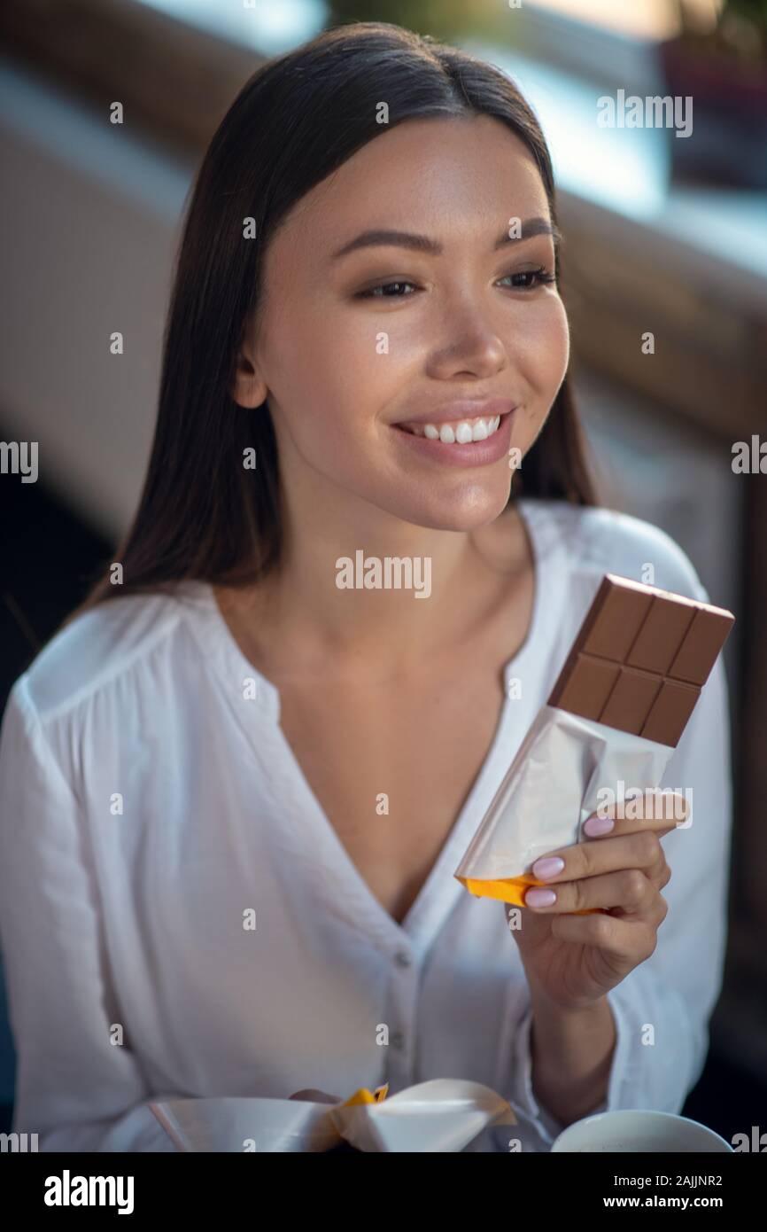 Face of a happy young woman eating chocolate Stock Photo - Alamy