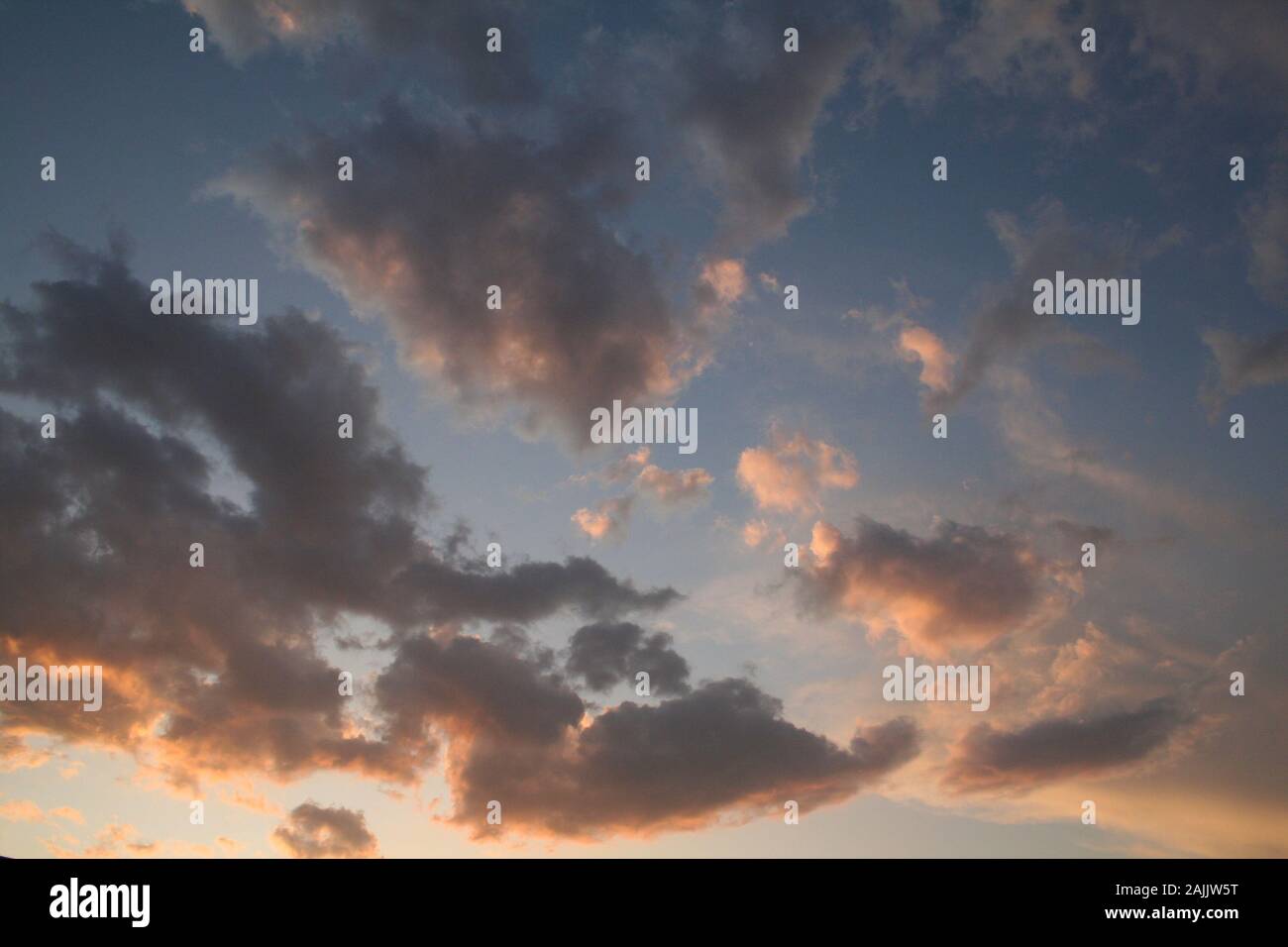 Clouds with sunlit edges in blue sky Stock Photo - Alamy