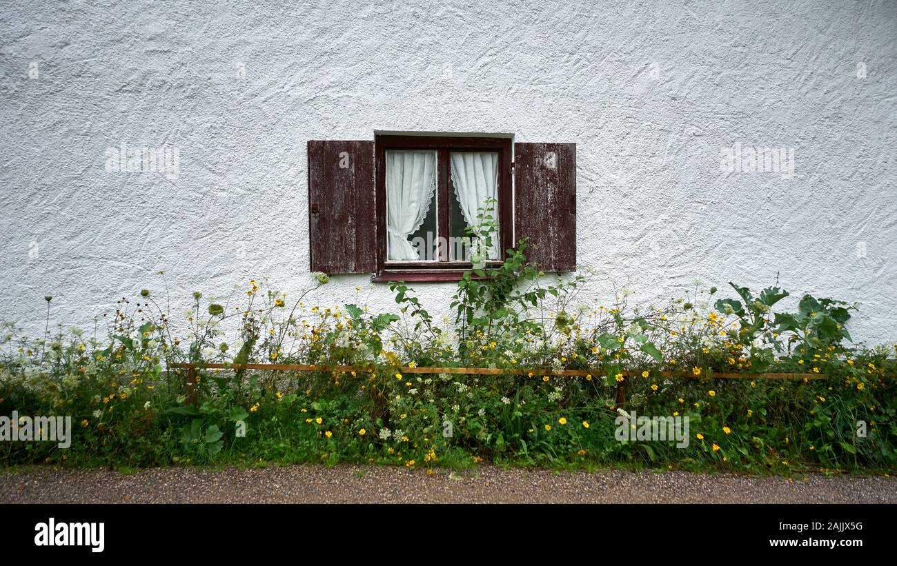 Generic white stucco wall with single old window with weathered ...