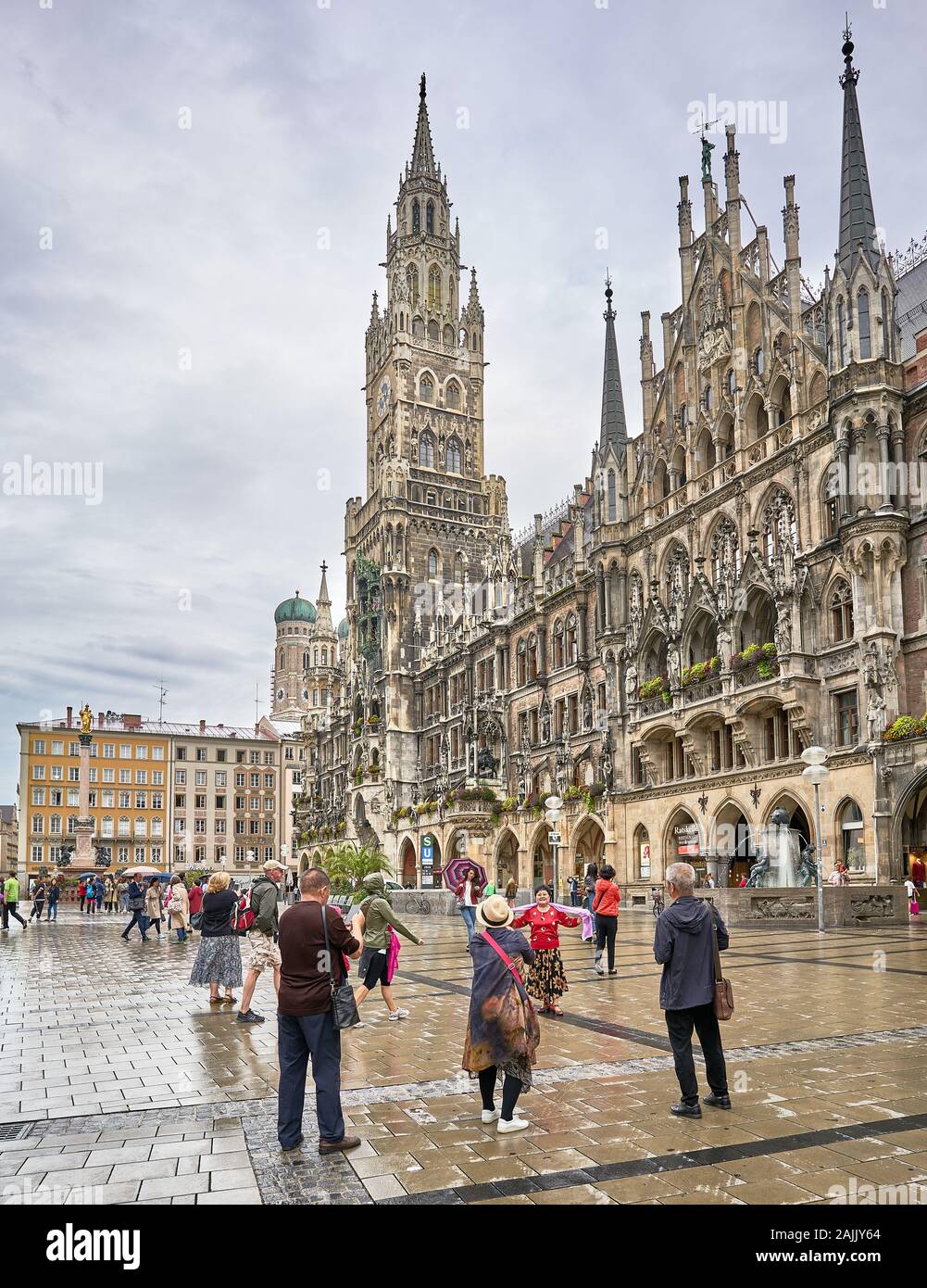 Group of Asian tourists take selfies in front of the city hall or ...