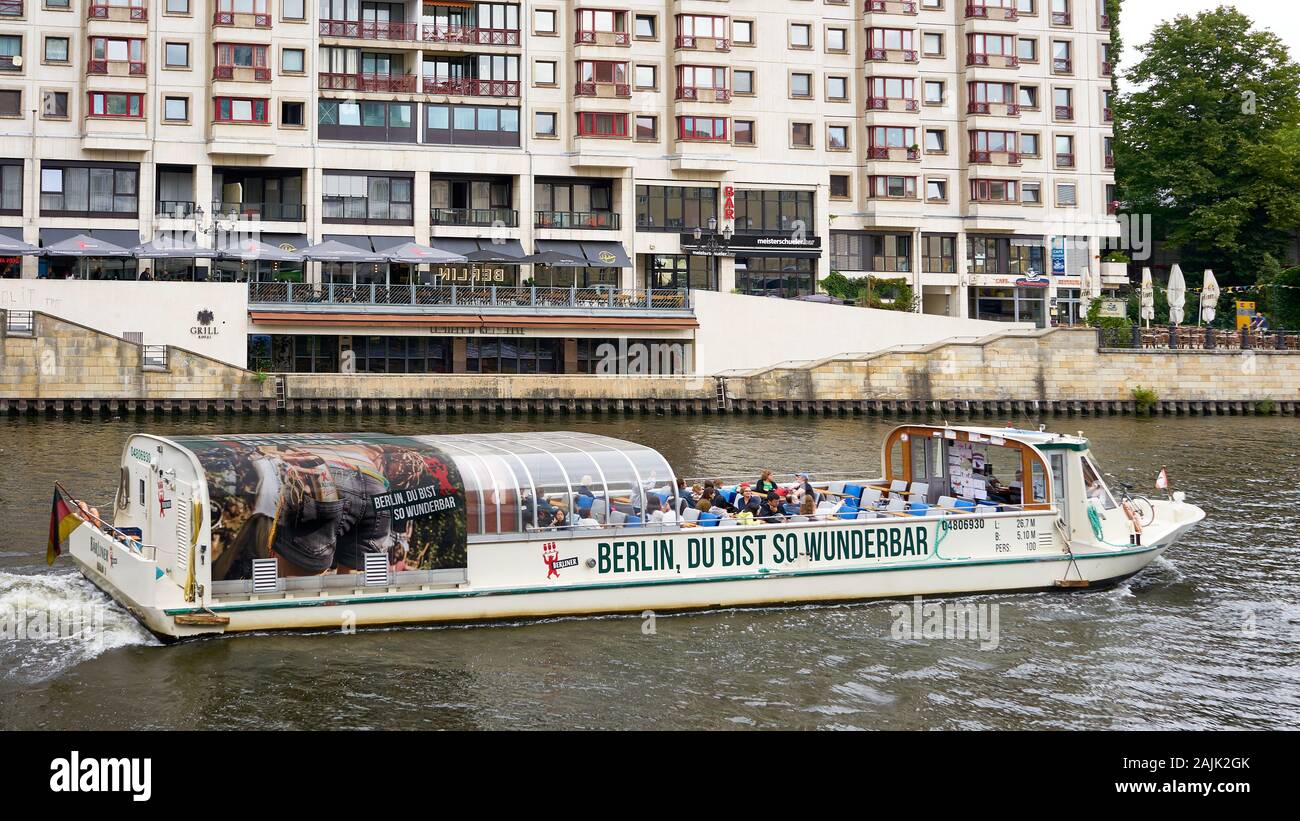 Tour boat with tourists glides along the Spree River in downtown Berlin ...