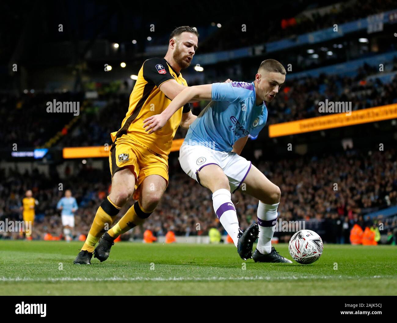 Port Vale's Tom Pope (left) and Manchester City's Taylor Harwood-Bellis ...