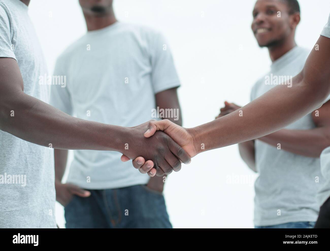 smiling guys shaking hands. isolated on white Stock Photo - Alamy