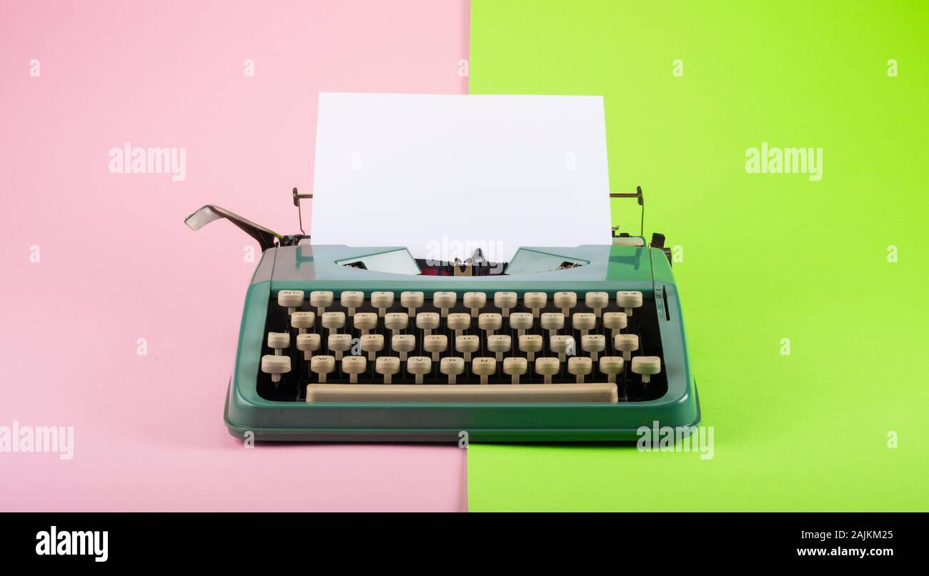 Vintage typewriter with paper sheet on pink and green background Stock ...