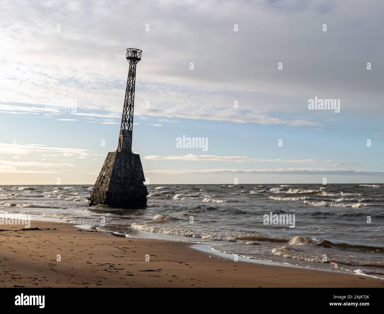 landscape with old and crooked lighthouse by the sea, windy day by the ...