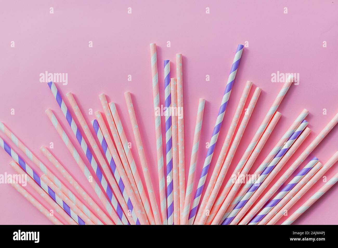 Striped drink straws of different colors in row isolated on yellow ...