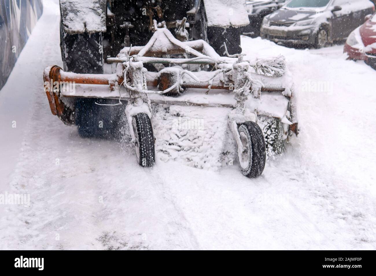 mechanical street sweeper brush trying to sweep snow off the sidewalk ...