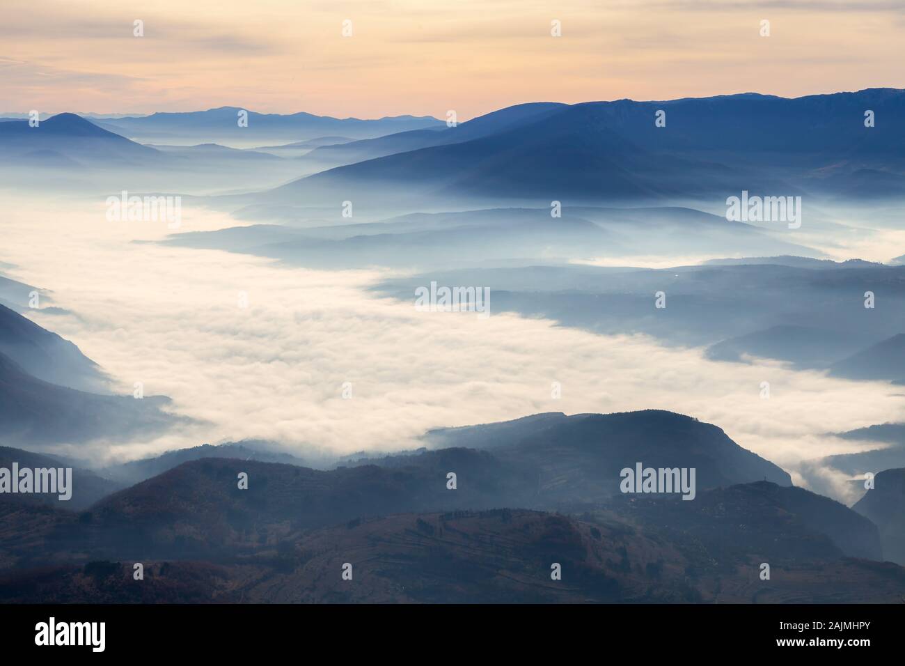 Vantage point view of valley filled with morning mist lighten by ...