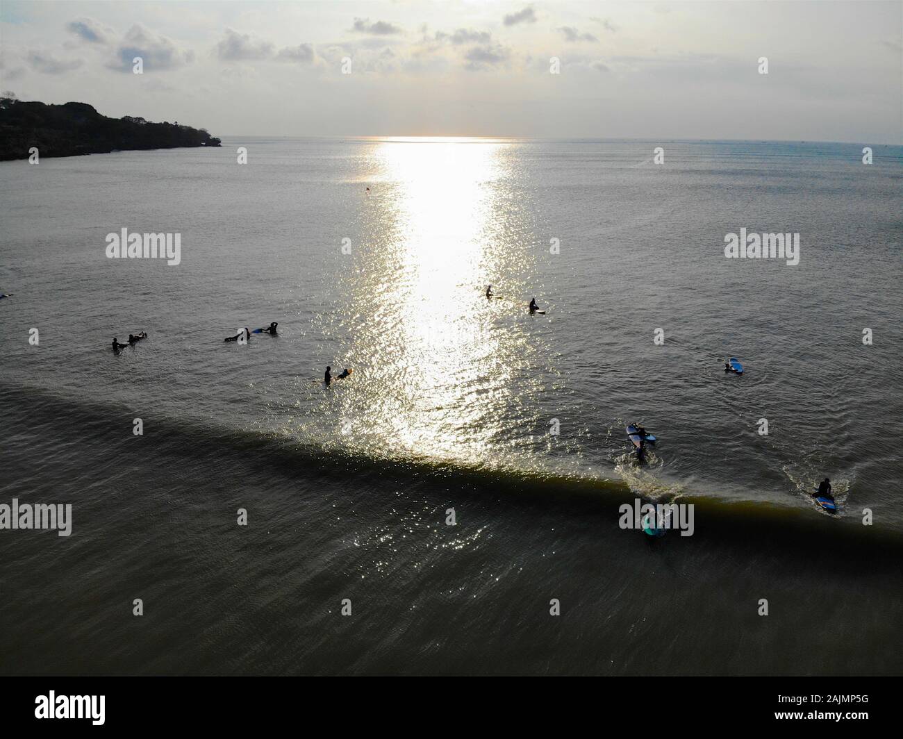 Aerial view of surfers on their board waiting the waves during sunset ...