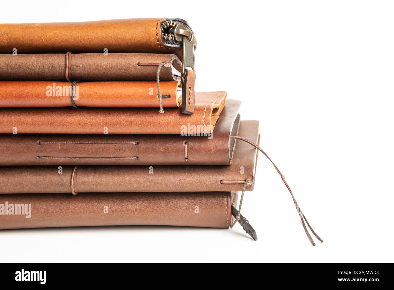 A stack of leather-bound journals, notebooks, cases, and wallets set on ...