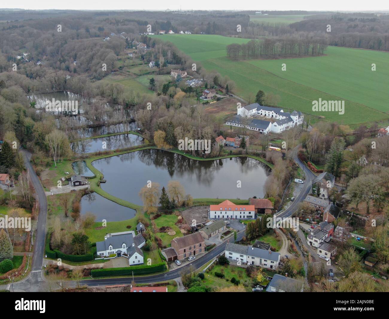 Aerial view of big villas with garden surrounded by forest during winte ...