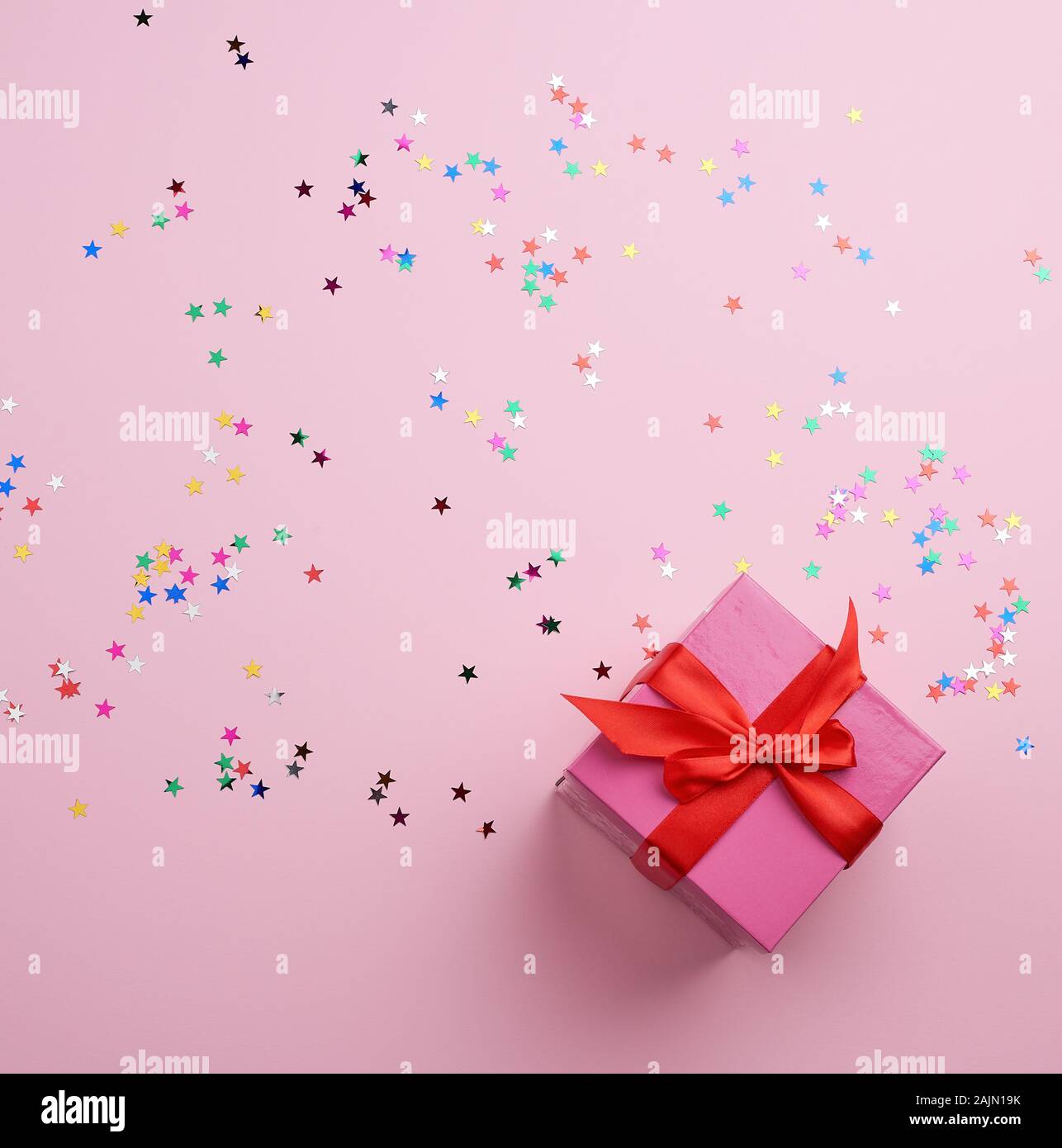 beautiful pink closed box with a big bow on a pink background with ...