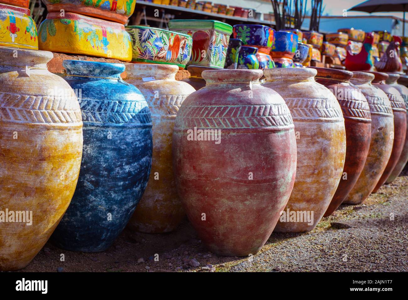 An assortment of patinas in primitive style pots and assorted colorful ...