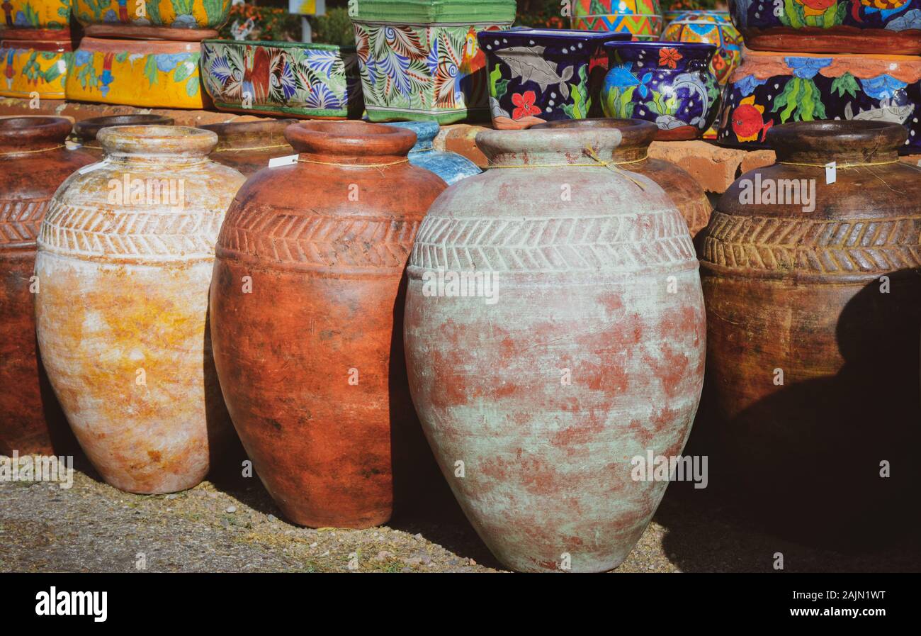 An assortment of patinas in primitive style pots and assorted colorful ...