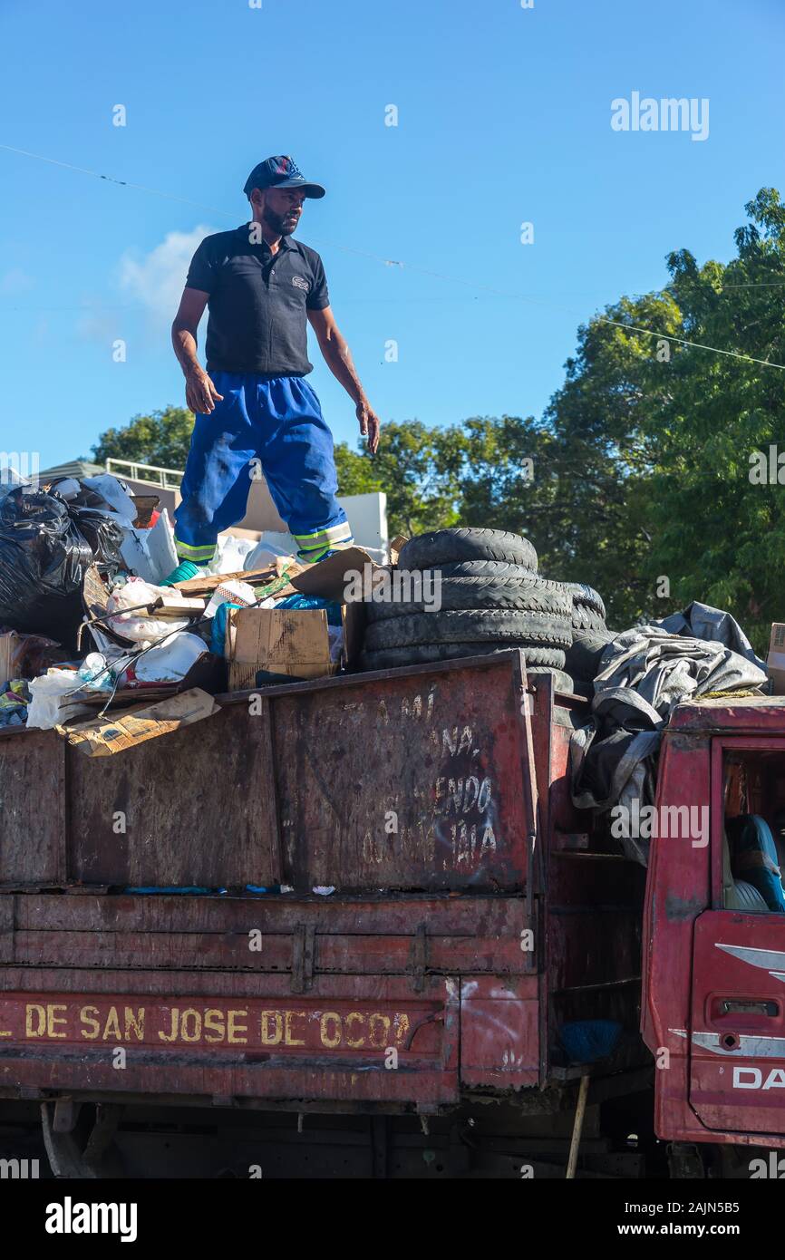 dramatic image of garbage workers on a garbage truck dumping trash cans ...